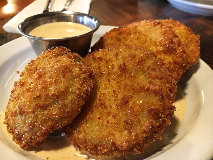 Golden-brown discs of fried green tomato perfection that would make Fannie Flagg weep with joy. The cornmeal crust shatters with each bite, revealing tangy treasure within.