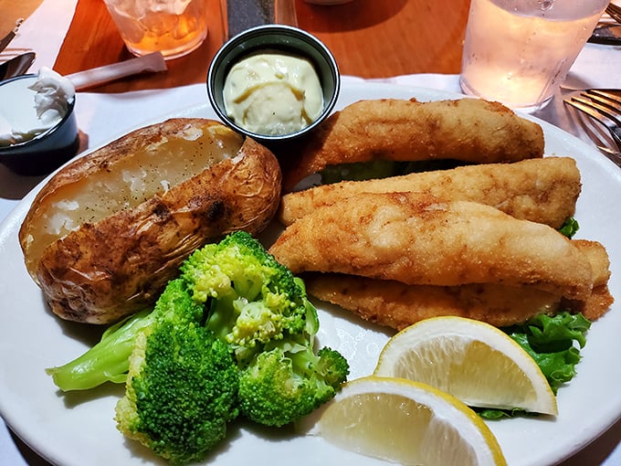 Golden-fried perch fillets that shatter with each bite, served alongside a baked potato that's practically begging to be smothered in butter.