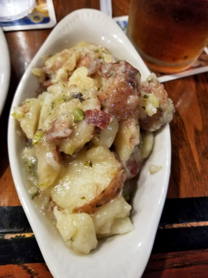 The star of the show: warm German potato salad that makes you question every mayo-based version you've ever encountered. Those bacon bits aren't just garnish&mdash;they're game changers.