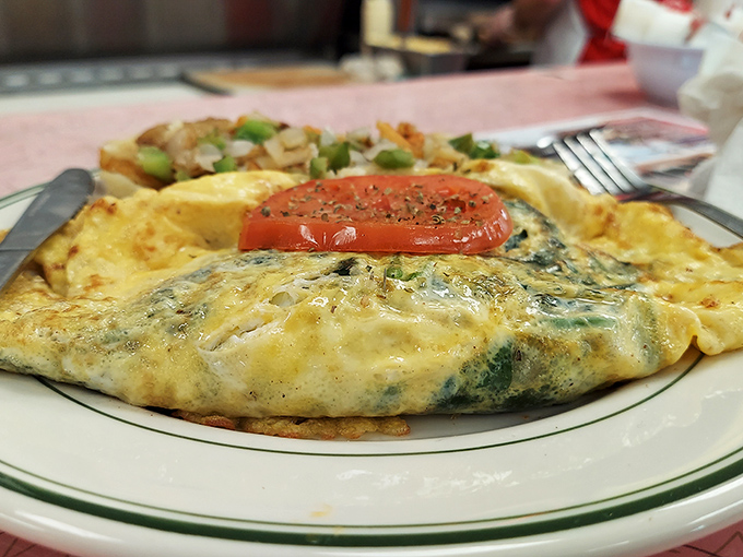The legendary Greek omelet arrives like a fluffy yellow pillow stuffed with Mediterranean dreams. That slice of tomato on top? The cherry on this savory sundae.