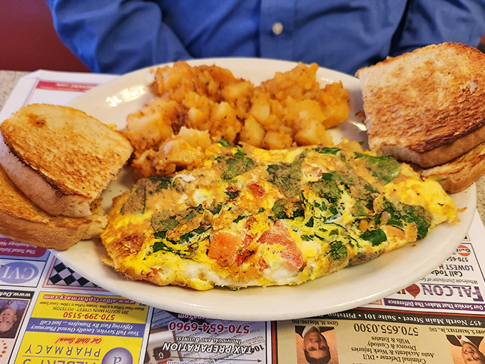 This isn't just any omelet&mdash;it's a masterclass in breakfast architecture with perfectly golden edges and a garden of vegetables tucked inside.