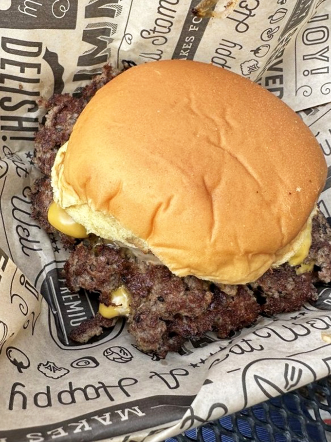 This isn't just a burger&mdash;it's edible architecture with crispy-edged beef spilling beyond the bun's borders in delicious rebellion.