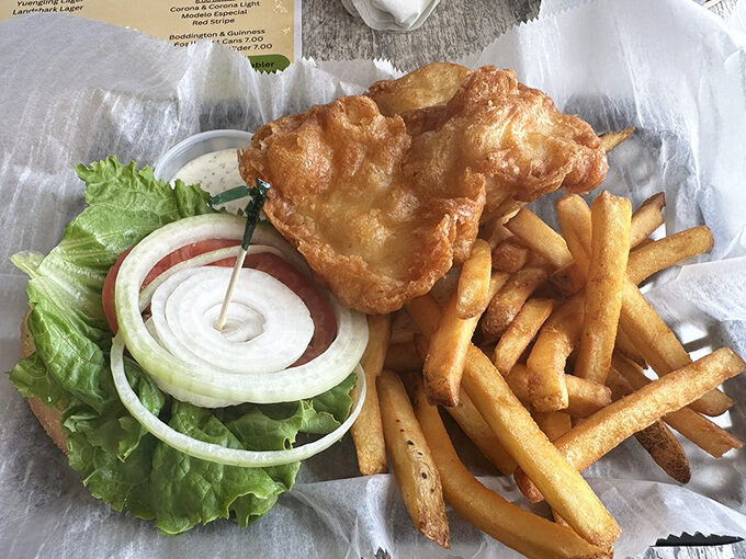 The legendary grouper sandwich in its natural habitat &ndash; golden-battered perfection nestled alongside crispy fries. Worth every mile of the drive.