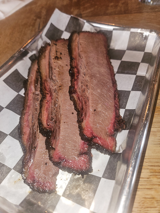 Behold the star of the show: brisket with that perfect pink smoke ring. Poetry doesn't get more beautiful than this meat masterpiece.