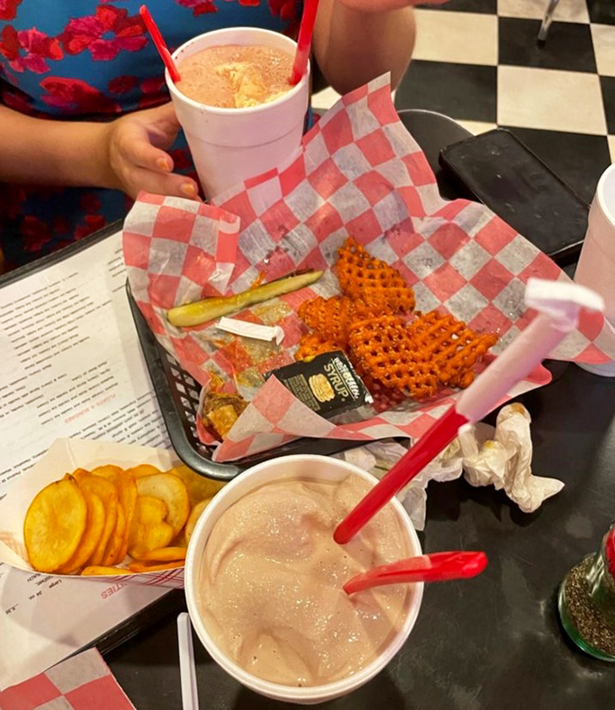 Sweet salvation arrives in a basket! Those waffle fries and milkshakes aren't just food—they're edible nostalgia served with red-and-white checkered flair.