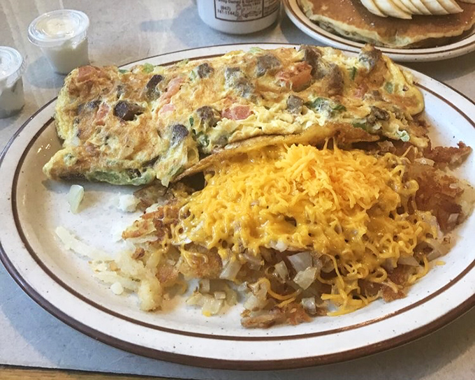 The star of our story: golden-brown hash browns sharing a plate with a fluffy omelet. That cheese pull is what breakfast dreams are made of.