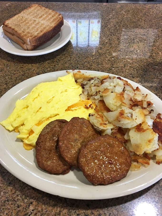 Behold the holy trinity of breakfast perfection: golden home fries, fluffy scrambled eggs, and sausage patties that mean business.