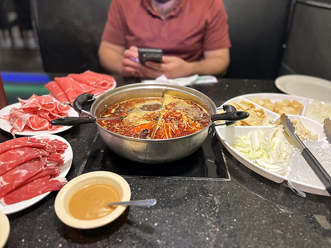 Hot pot heaven awaits the brave, where thin-sliced meats transform in the bubbling cauldron of spicy broth like culinary alchemy.
