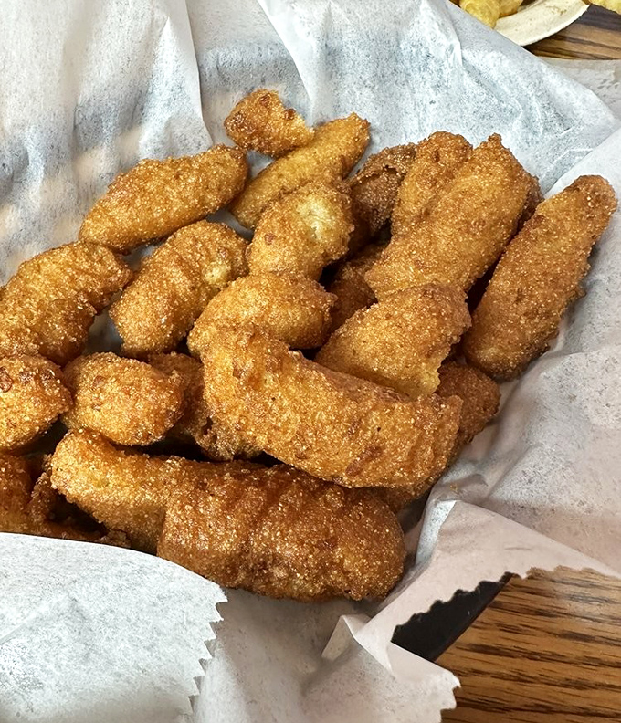 Golden-brown hush puppy perfection that makes you question why you've wasted time eating inferior versions. These crunchy cornmeal miracles deserve their own fan club.