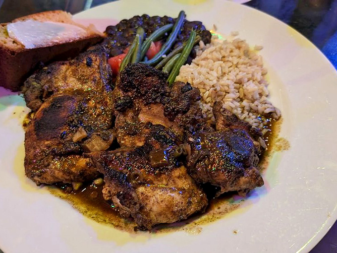 The legendary Jamaican jerk chicken arrives like a flavor explosion, sporting a blackened spice crust that would make even the most stoic food critic weep with joy.