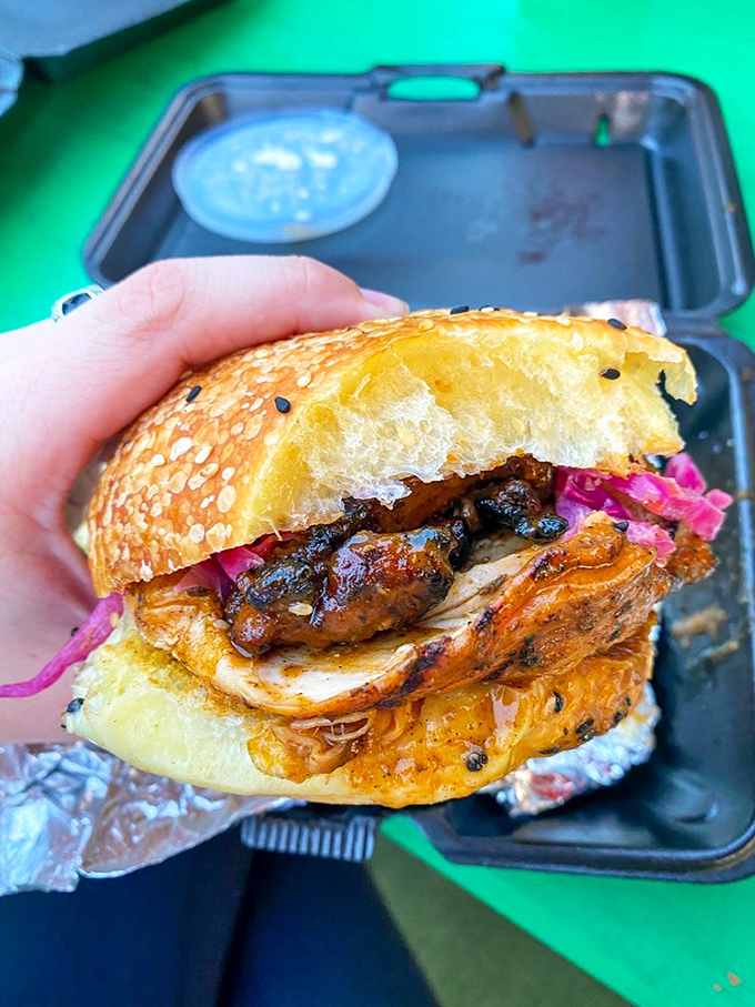 Sandwich architecture at its finest! This jerk chicken creation balances sweet bun, smoky meat, and that pop of pickled cabbage &ndash; a handheld masterpiece demanding your immediate attention.