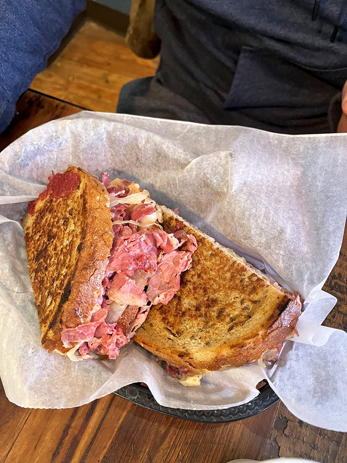 Not all heroes wear capes—some come wrapped in wax paper, stacked with perfectly pink corned beef and melty Swiss on grilled rye bread.