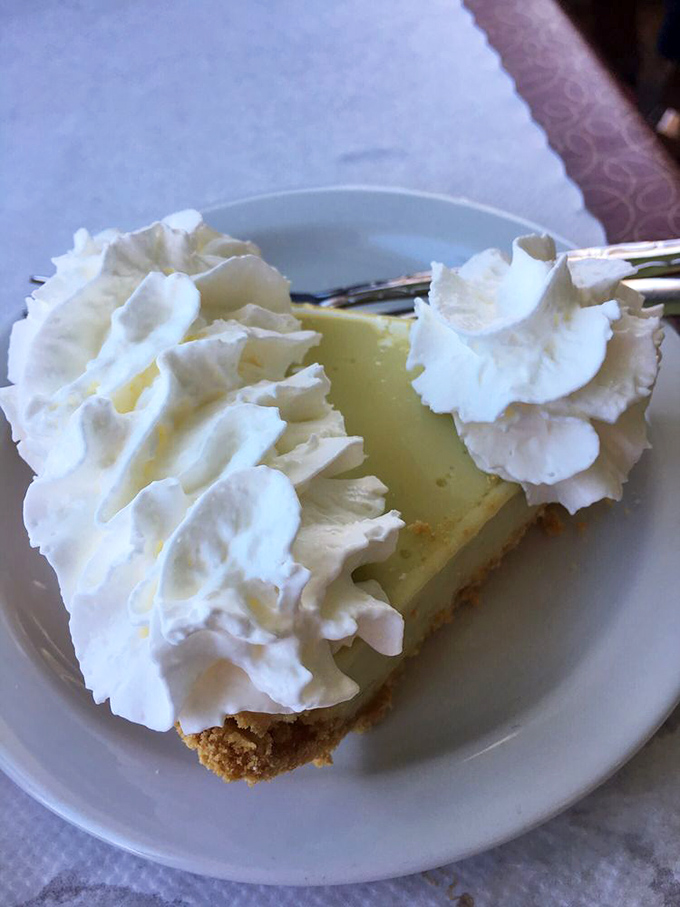 The key lime pie arrives like a citrus dream—tart filling cradled in graham cracker crust, crowned with clouds of whipped cream.