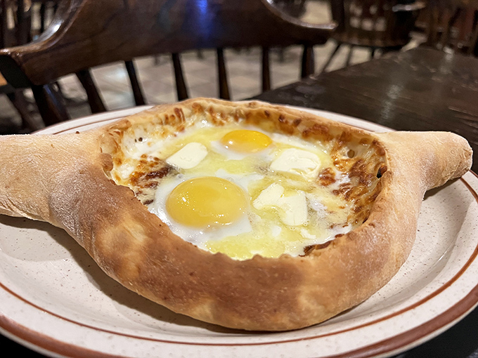 Behold the legendary Adjarsky khachapuri—a boat-shaped bread filled with molten cheese and crowned with sunny egg yolks. Cardiologists hate it, taste buds worship it.