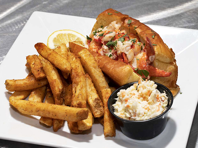 This lobster roll isn't just a sandwich—it's a coastal vacation between two perfectly toasted buns, with seasoned fries playing supporting role.