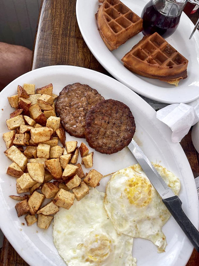 Breakfast of champions! Golden home fries, perfectly cooked eggs, and sausage patties that would make even the most dedicated dieter temporarily abandon their resolve.