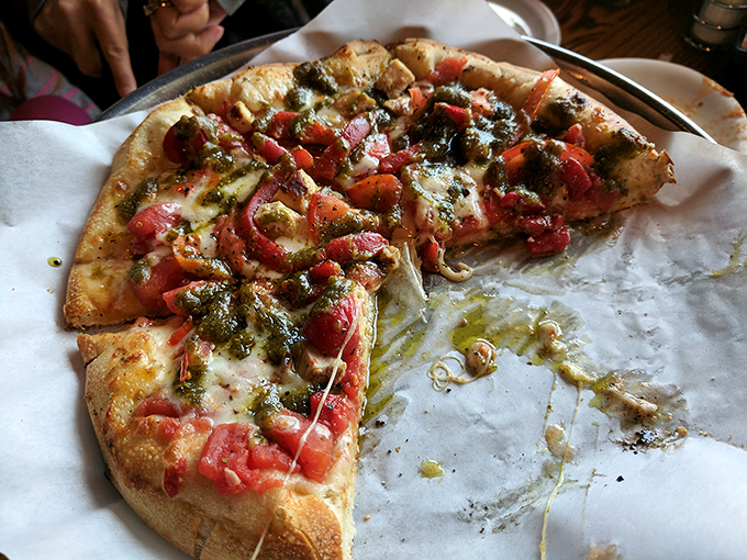 Pizza perfection doesn't need to shout. This pesto-topped beauty whispers "I was made with care" with every bite. The oil slick? That's flavor gold.