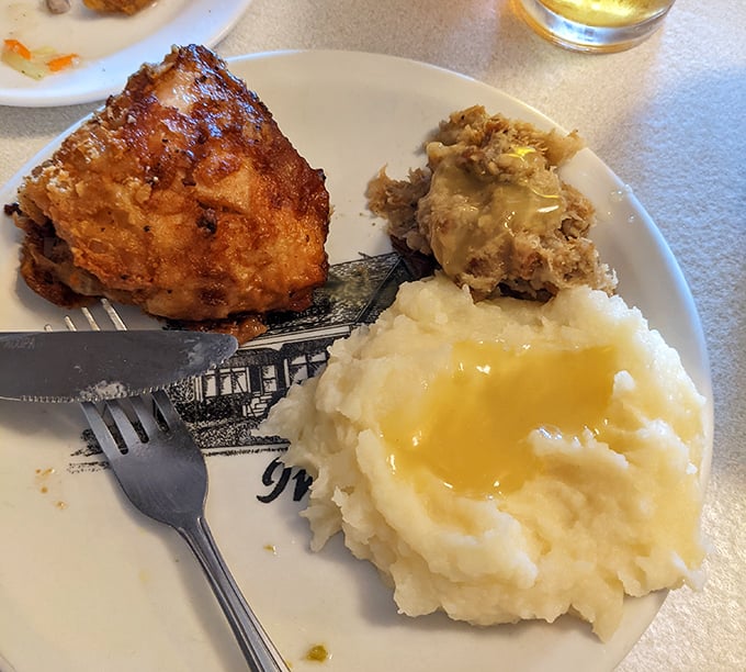 Behold: the holy trinity of comfort food. Golden-fried chicken, cloud-like mashed potatoes with a pool of gravy, and something mysterious that looks suspiciously delicious.