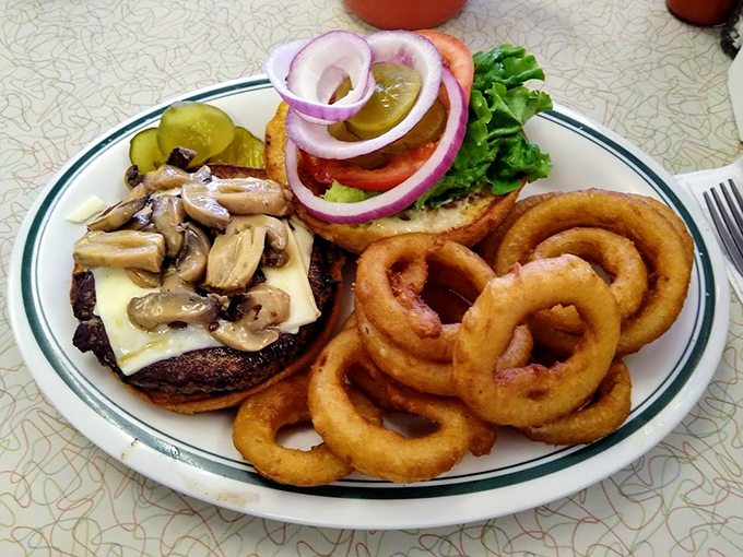 A burger that means business, flanked by onion rings that could double as golden halos. This isn't just lunch&mdash;it's a commitment to happiness.
