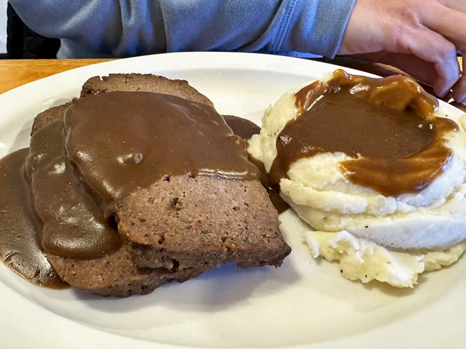 The infamous meatloaf in all its glory. Tender, perfectly seasoned, and smothered in gravy that should require a license to serve. Worth every calorie.