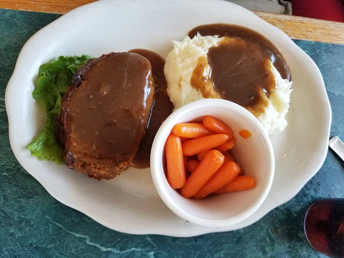 Behold, the star of the show! Meatloaf bathed in rich brown gravy with mashed potatoes and carrots&mdash;a plate that whispers, "Nap time follows."