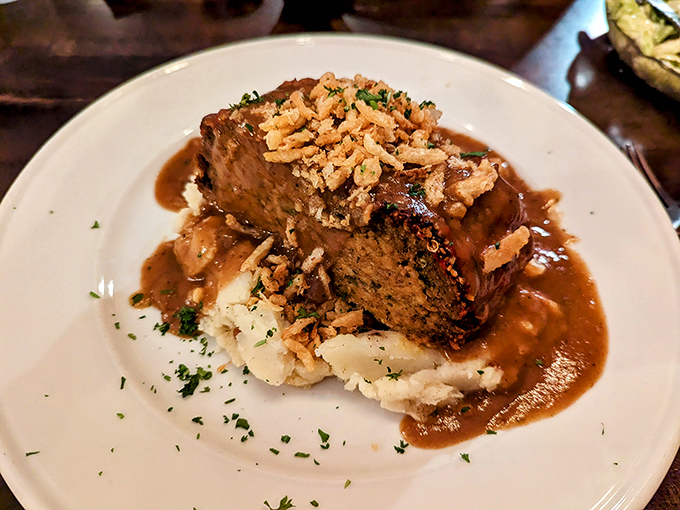The legendary meatloaf in all its glory&mdash;sitting atop cloud-like mashed potatoes, bathed in savory gravy, and topped with crispy onions. Comfort food elevated to an art form.