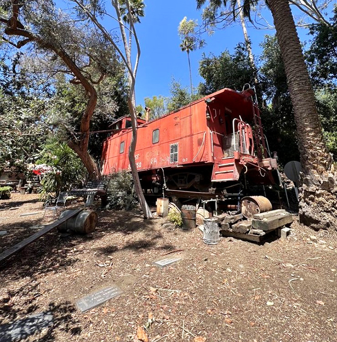 Not your average backyard feature&mdash;a vintage red caboose nestled among palm trees. California dreaming with a railroad twist!
