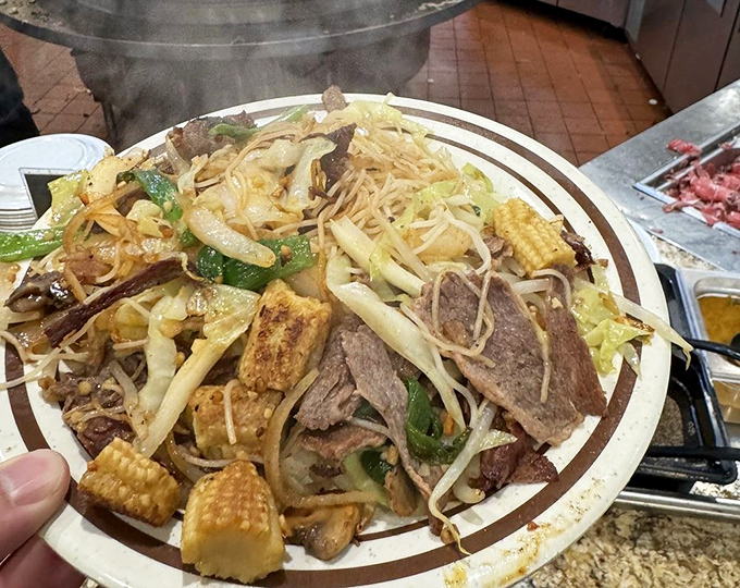 Mongolian BBQ nirvana! A mountain of noodles, vegetables, and proteins that would make even the most disciplined dieter whisper, "Worth it."