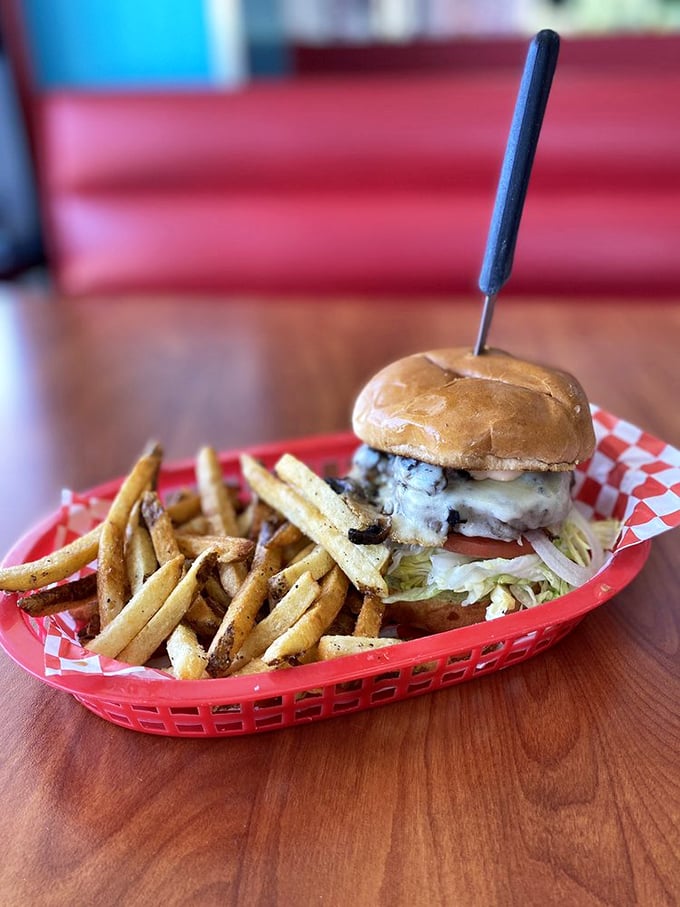 A burger that demands respect and possibly a chin napkin. Golden fries stand at attention beside this towering creation that makes fast food chains weep with inadequacy.