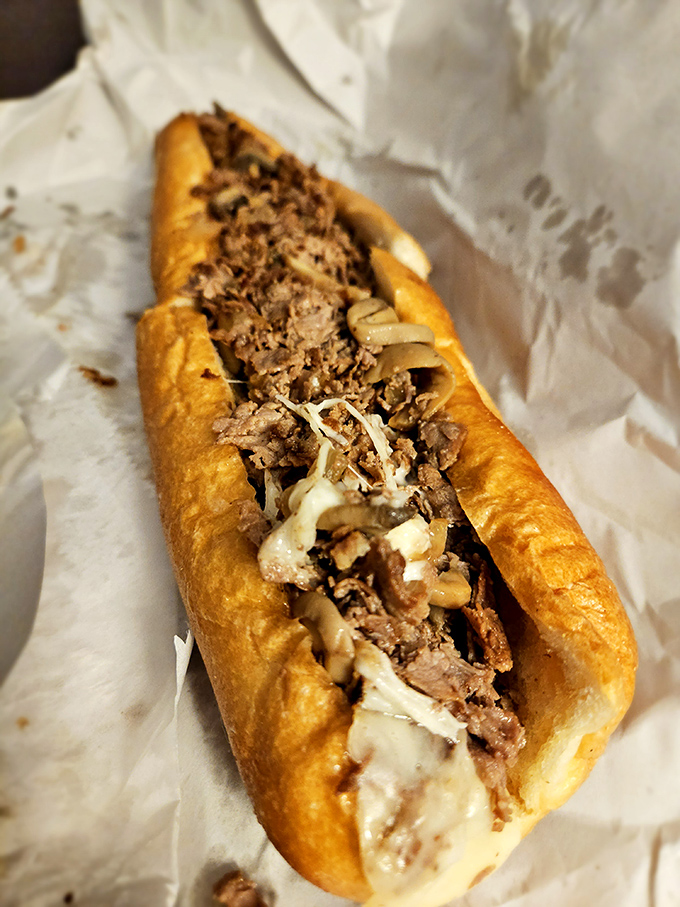 Behold the mushroom cheesesteak in its natural habitat: tender beef nestled under a blanket of melted cheese and saut&eacute;ed mushrooms. Poetry on a roll.