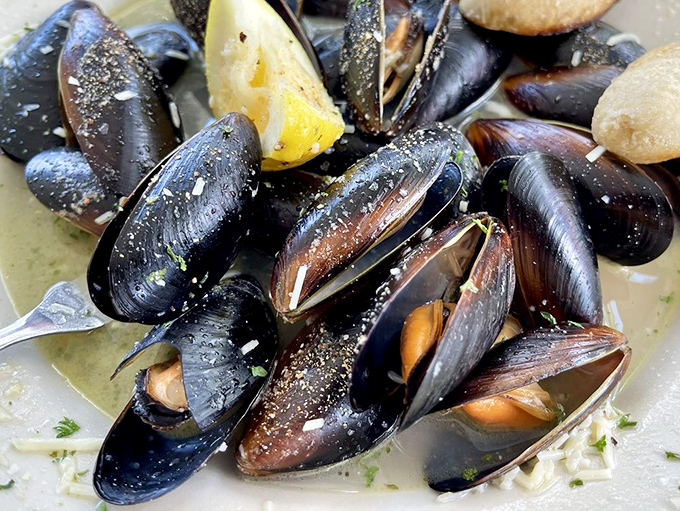 These mussels aren't just opened, they're having a full-blown conversation with that white wine sauce. The lemon wedge stands by, ready to brighten every briny bite.