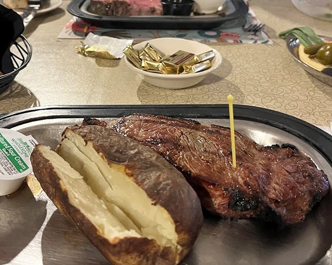 The star of the show arrives: a perfectly seared New York Strip alongside a baked potato that's practically begging for its butter bath.