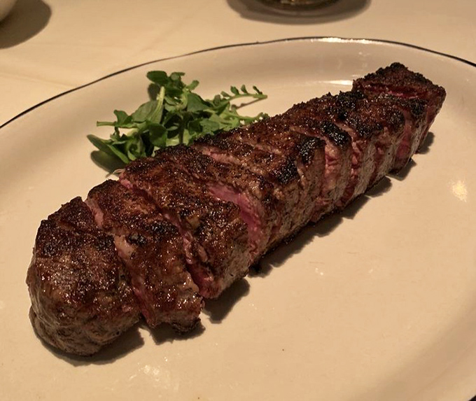 The New York Strip arrives like a masterpiece&mdash;perfectly charred exterior giving way to a rosy interior. This isn't just steak; it's edible poetry.