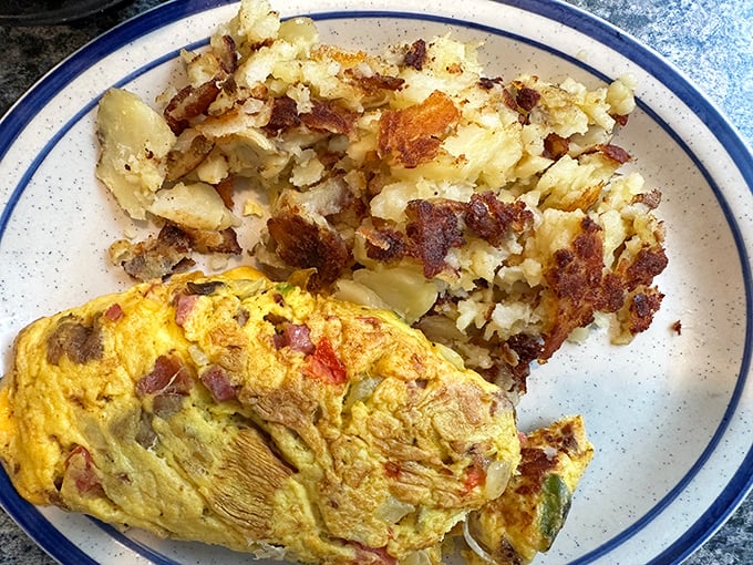 This omelet doesn't just whisper "good morning"—it belts it out like Aretha Franklin, accompanied by a chorus line of perfectly crisped home fries.