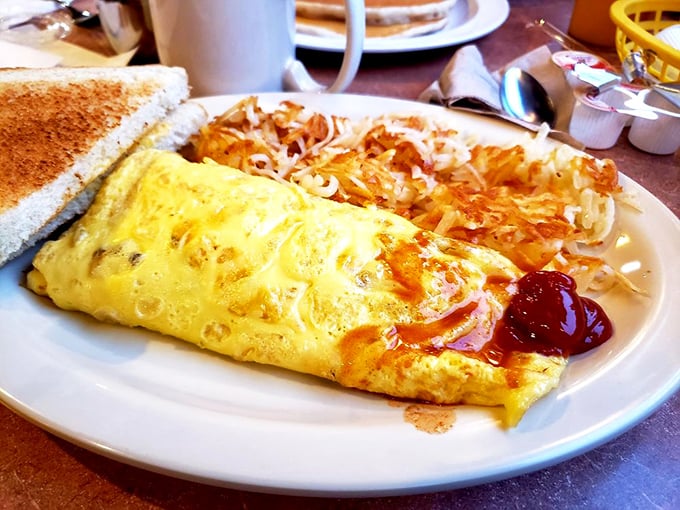 Behold the star attraction: an omelet that's achieved perfect fluffiness, paired with crispy hash browns that would make any potato proud.