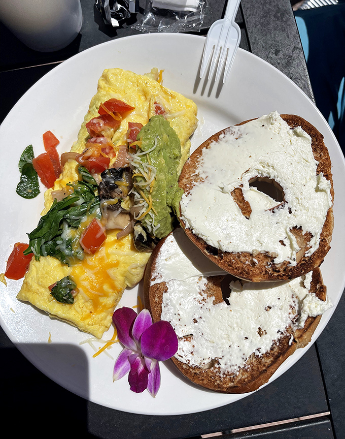 A perfect omelet meets its soulmate: a generously schmeared bagel. That purple orchid isn't just garnish&mdash;it's celebrating this beautiful union.