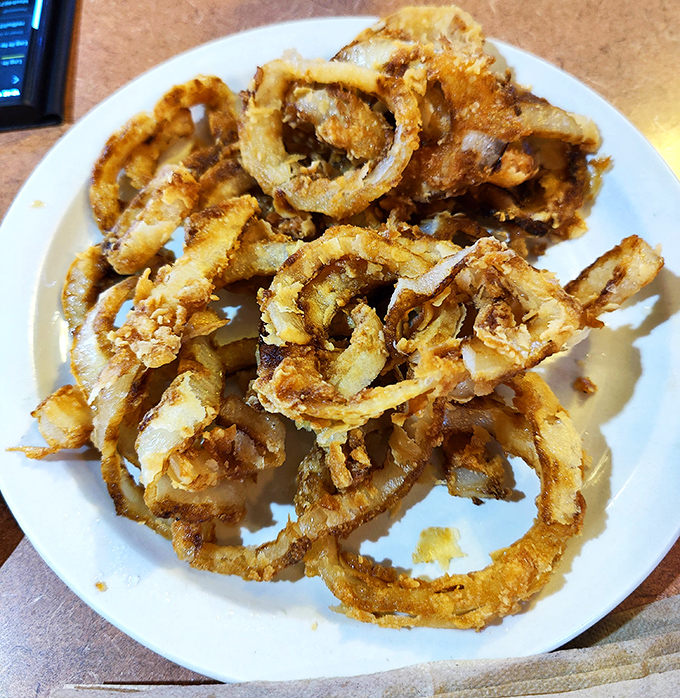 Behold the stars of the show! These golden-brown onion rings aren't just fried&mdash;they're transformed into crispy halos of perfection that demand a pilgrimage.