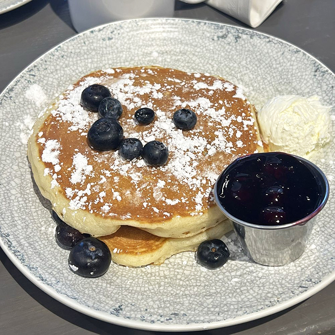 Blueberry pancakes dusted with powdered sugar and served with fresh compote&mdash;proof that sometimes the simplest pleasures are worth standing in line for.