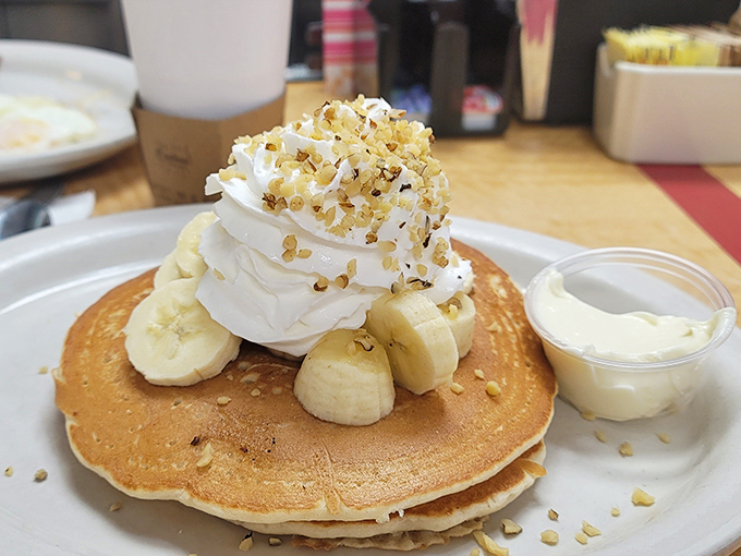 Pancakes crowned with whipped cream, bananas, and what appears to be walnut crumble&mdash;proof that breakfast can indeed be the most important art of the day.