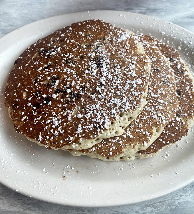 Golden-brown pancakes dusted with powdered sugar&mdash;the kind that make you wonder why anyone bothers with fancy brunch when diners perfected breakfast decades ago.