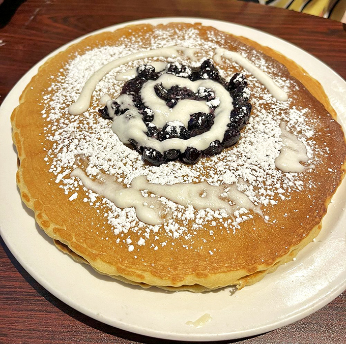 This isn't just a pancake; it's a golden canvas of joy with a blueberry spiral that makes you question why all breakfast isn't this beautiful.