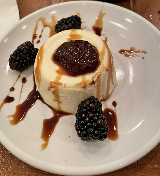 The panna cotta arrives like a silky cloud, crowned with berry compote and surrounded by fresh blackberries. Wobble perfection achieved.