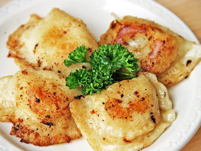 Golden-brown pierogies that crackle when your fork breaks through, revealing pillowy potato filling that's worth crossing state lines for.