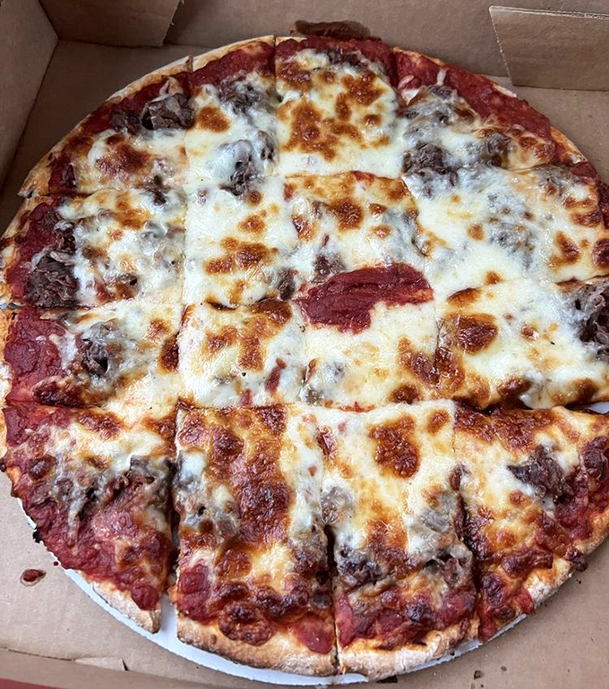 Pizza perfection in its natural habitat: a cardboard box. The melted cheese and generous toppings are practically performing a siren song.