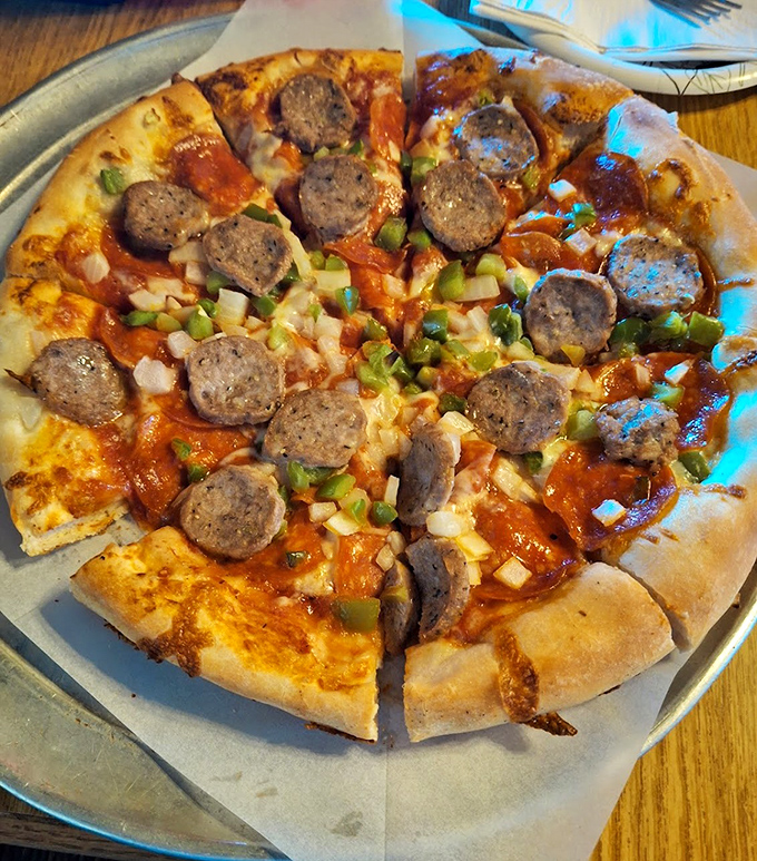 This pizza arrives looking like it means business, loaded with enough toppings to require structural engineering.