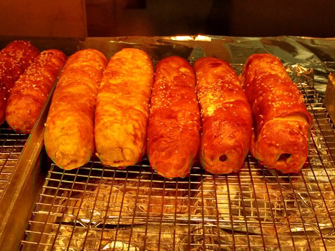 Fresh pretzel rolls cooling on racks, looking like golden pillows of carbohydrate heaven awaiting destiny.