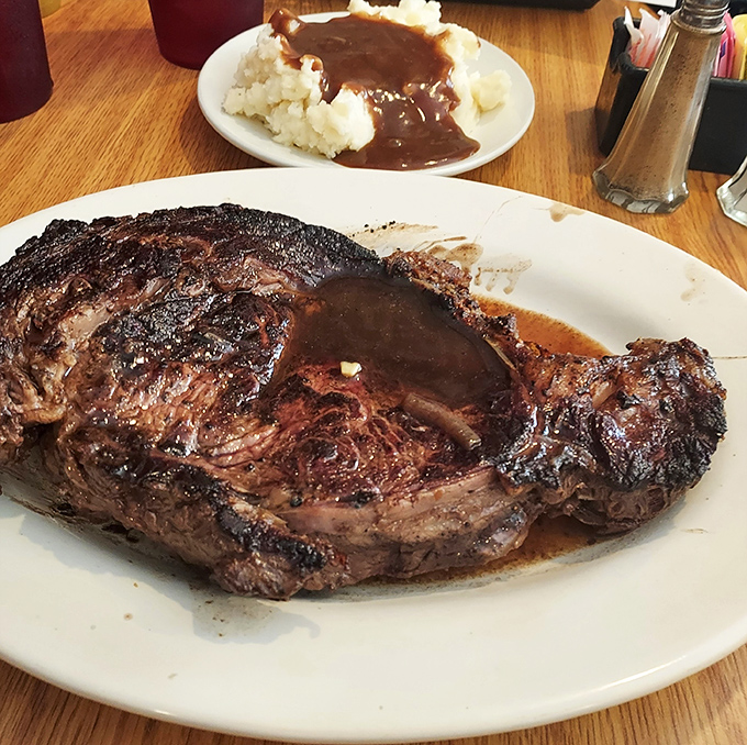 Behold the star attraction: prime rib so perfectly cooked it practically poses for its close-up, with a side of mashed potatoes drowning happily in gravy.