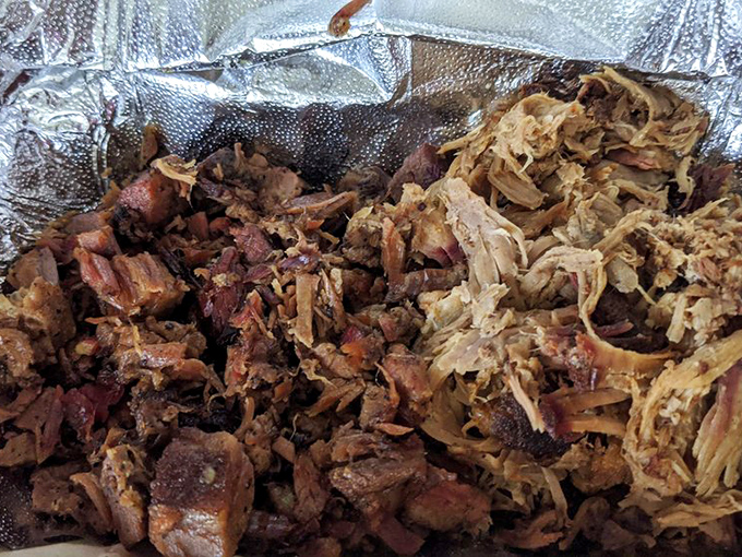 Pulled pork and brisket that looks like it's been kissed by smoke for hours. This isn't just meat; it's a time-honored tradition served in aluminum foil.