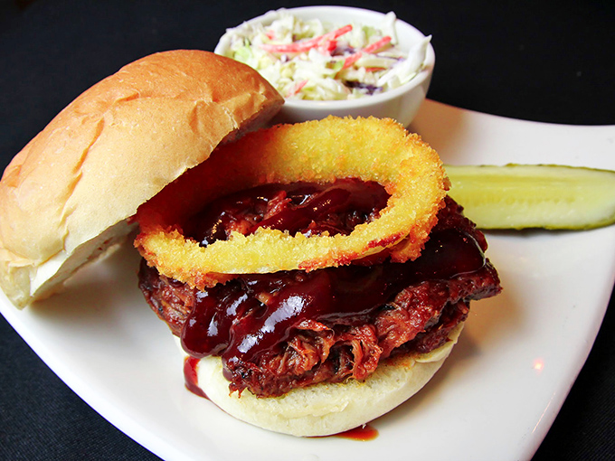 This isn't just a pulled pork sandwich&mdash;it's a barbecue masterpiece with slow-cooked meat, tangy sauce, and a crispy onion ring that'll make your taste buds do a victory dance.