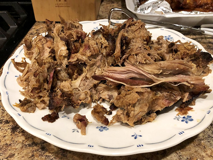 This pulled pork isn't just food; it's a masterclass in patience and smoke, with each strand telling the story of hours in the smoker.